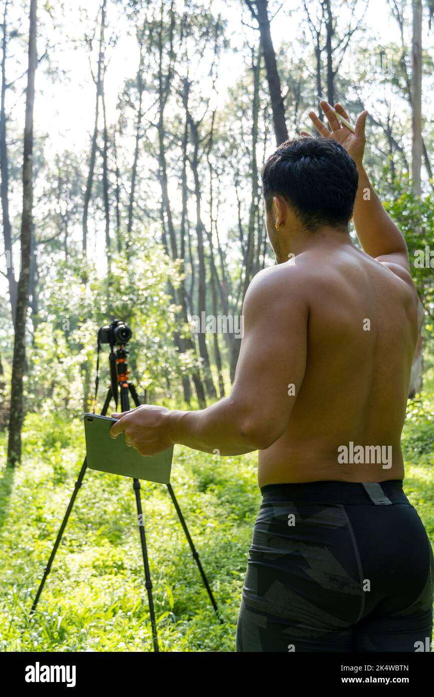 Mature middle-aged athlete man standing in stand position in sporty clothes on fitness mat ...