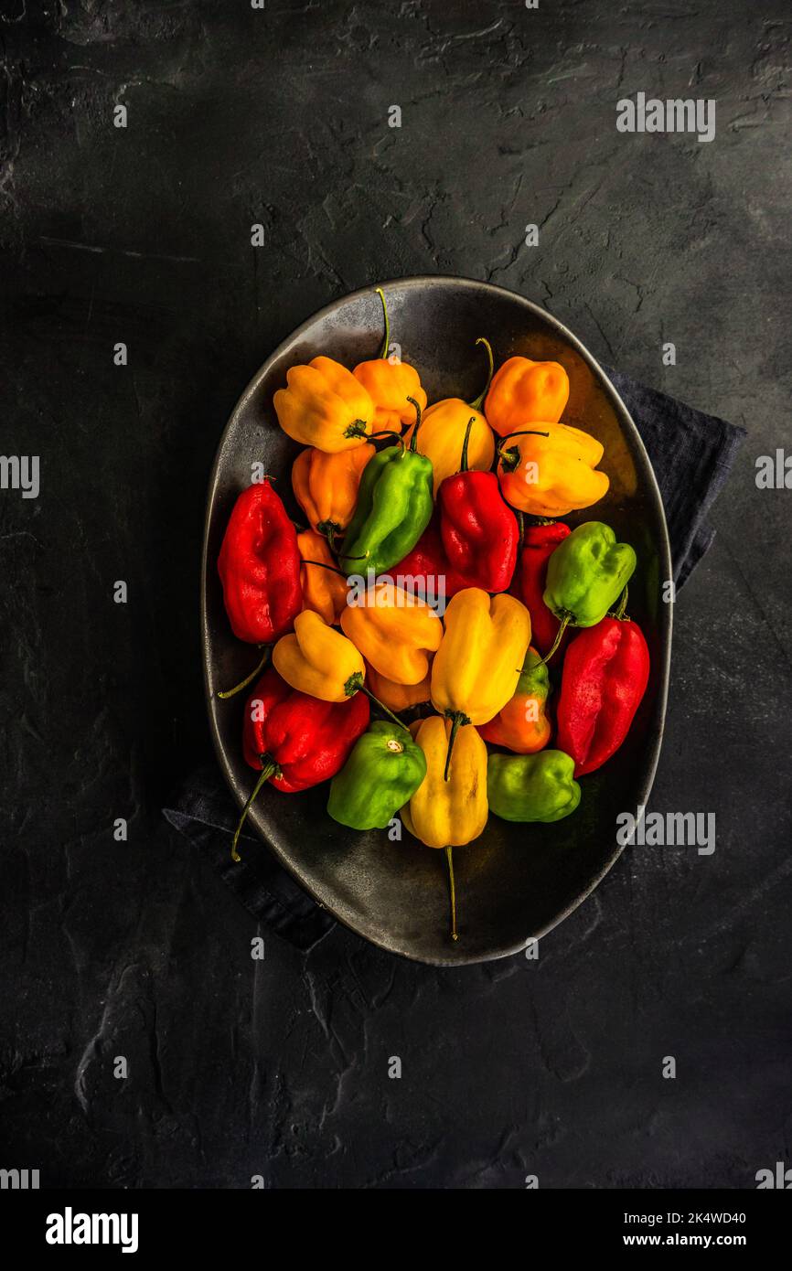Overhead view of a bowl of assorted red, yellow and green, chilli ...