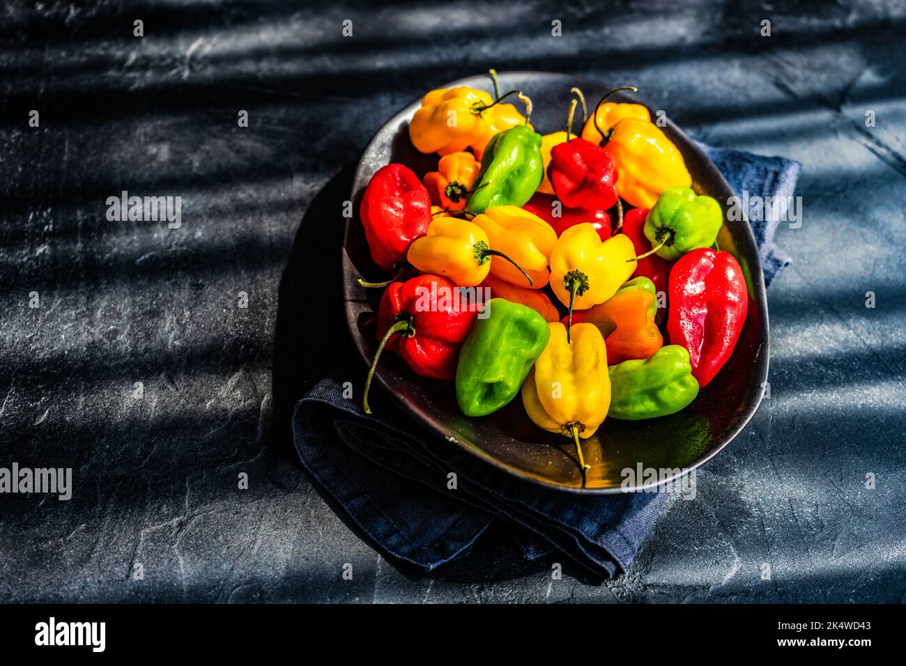Overhead view of a bowl of assorted red, yellow and green, chilli ...