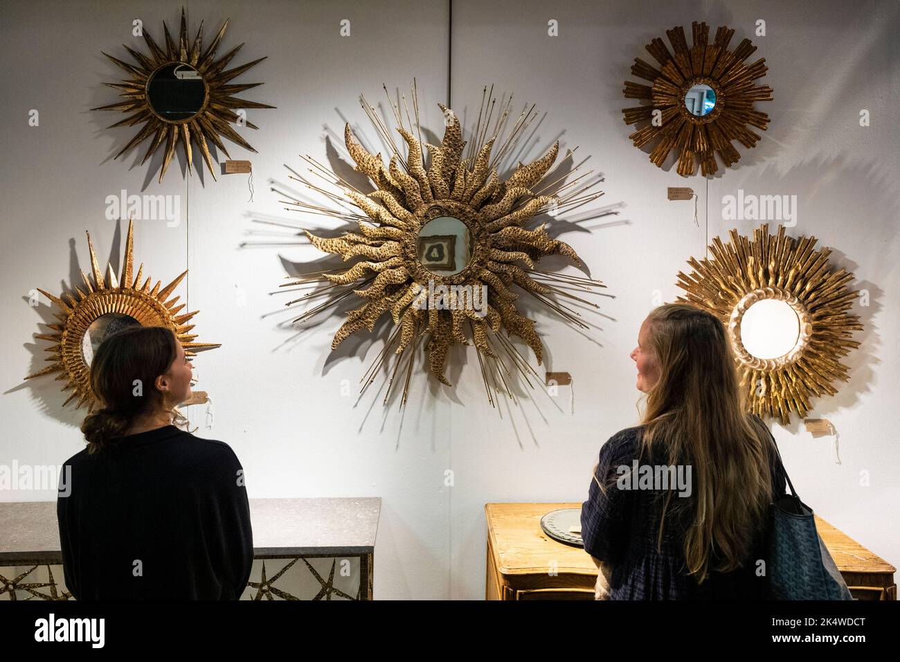 London, UK. 4 October 2022. Visitors view a selection of 1960s sunburst ...