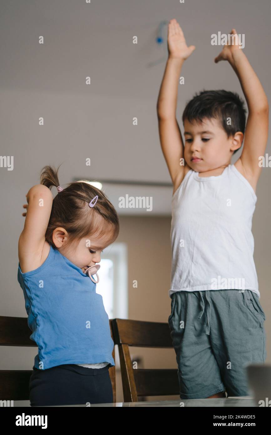 Two children waiting impatiently in the kitchen for their mother to ...
