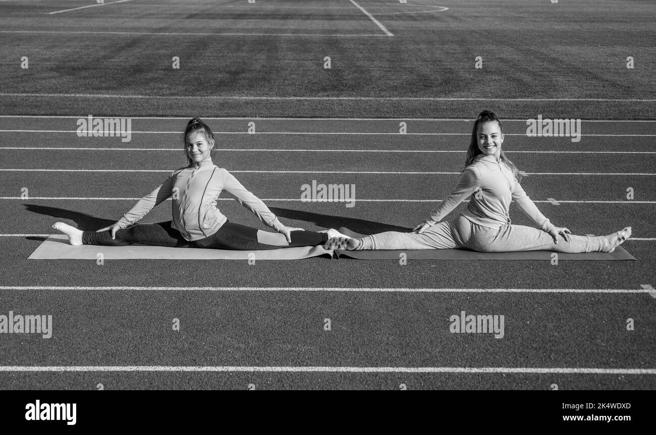 Grow in yoga. Flexible children do splits on stretch mat. Yoga and ...