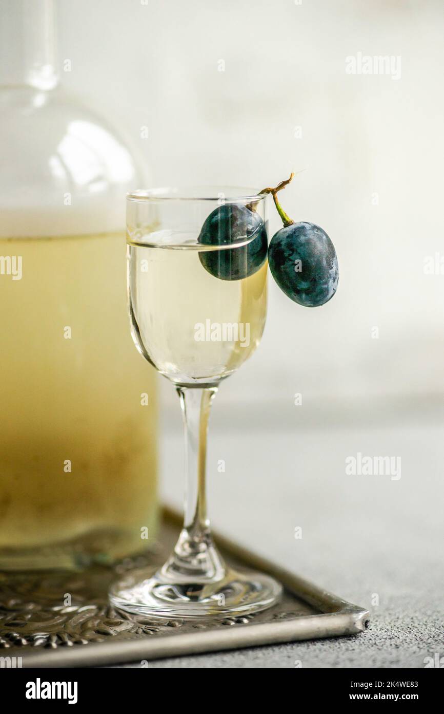 Glass of Georgian chacha on a metal tray with black grape garnish Stock ...