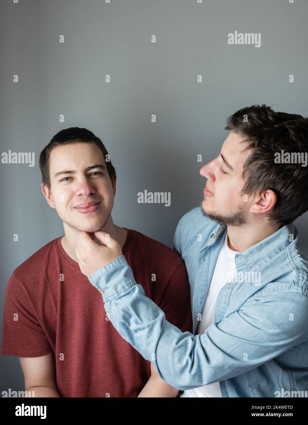 Portrait of a smiling man holding another man's face Stock Photo - Alamy