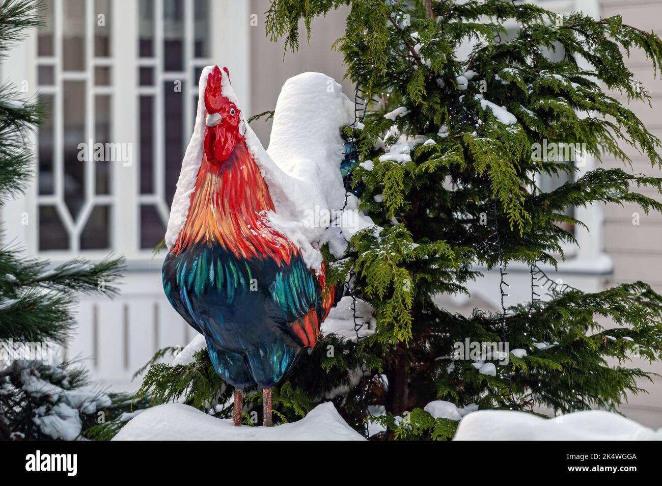 a snowy figure of a rooster and fir trees at the entrance of the cafe ...