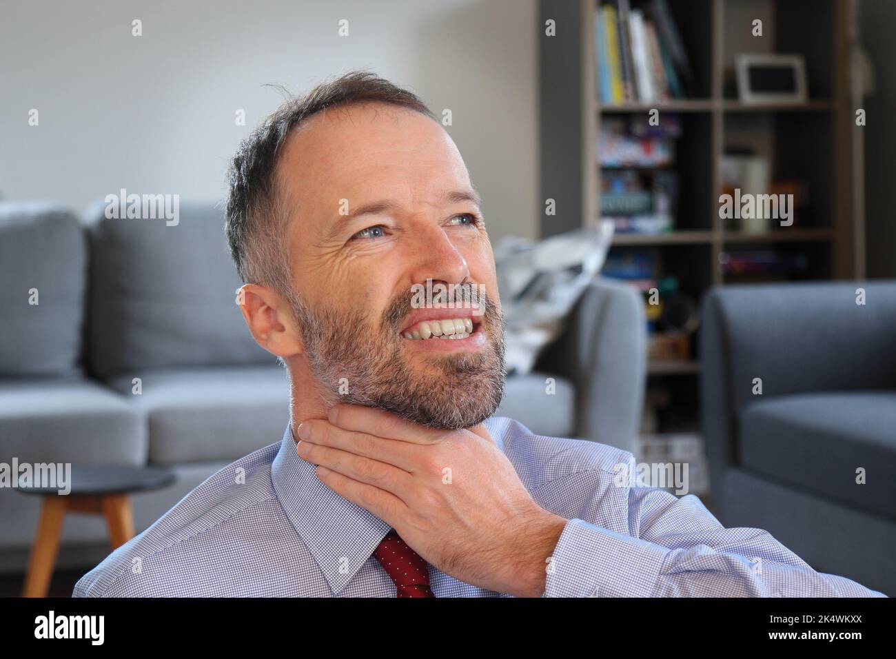 Man with sore throat with expression of pain. Bearded man wearing ...