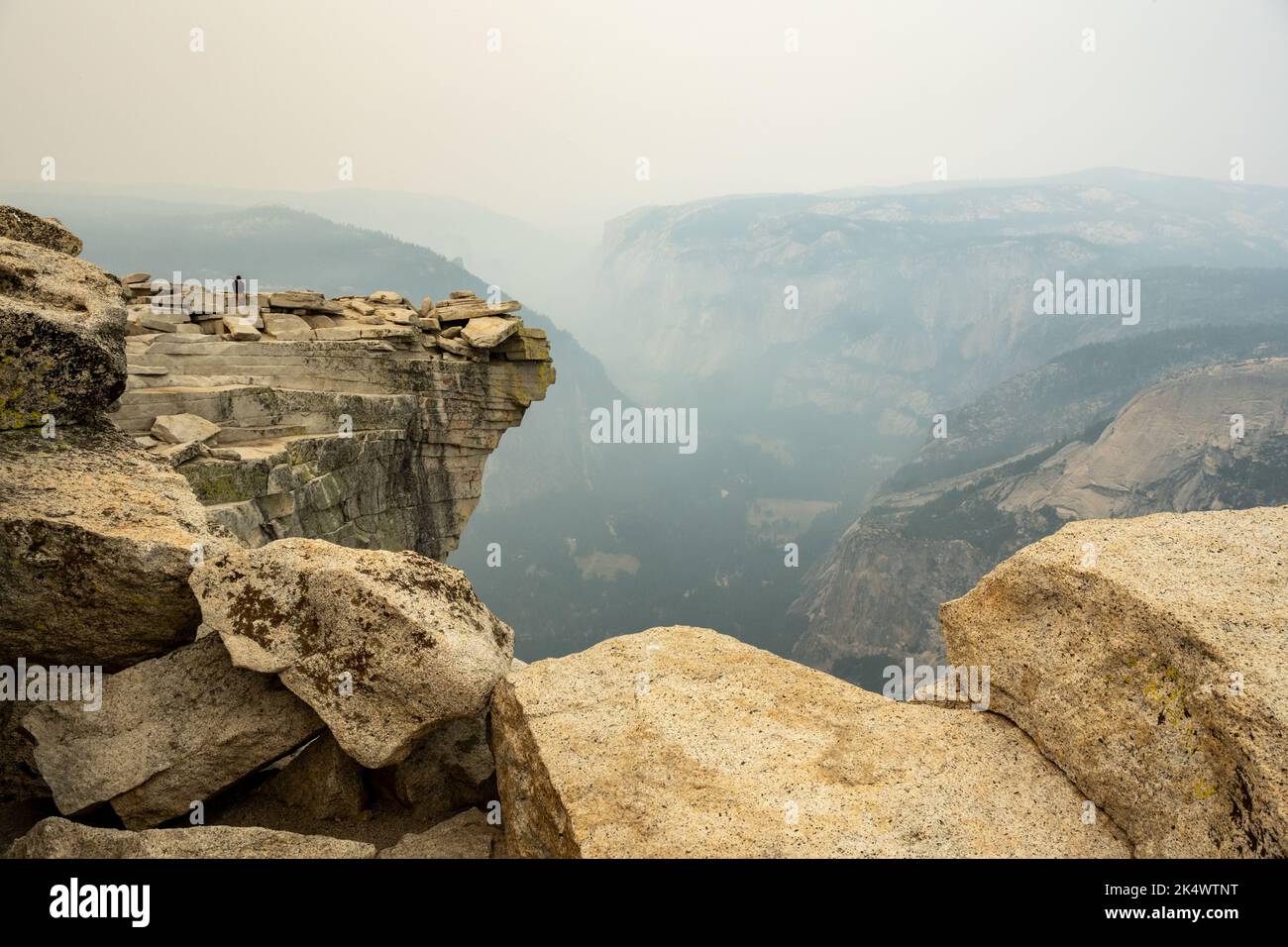 Single Person Sits On The Rocky Edge of Half Dome in Yosemite Stock Photo - Alamy