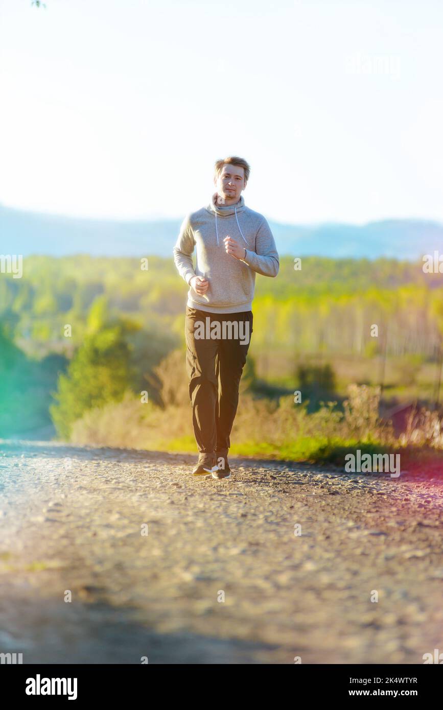 Running man jogging in rural nature at beautiful summer day. Sport ...