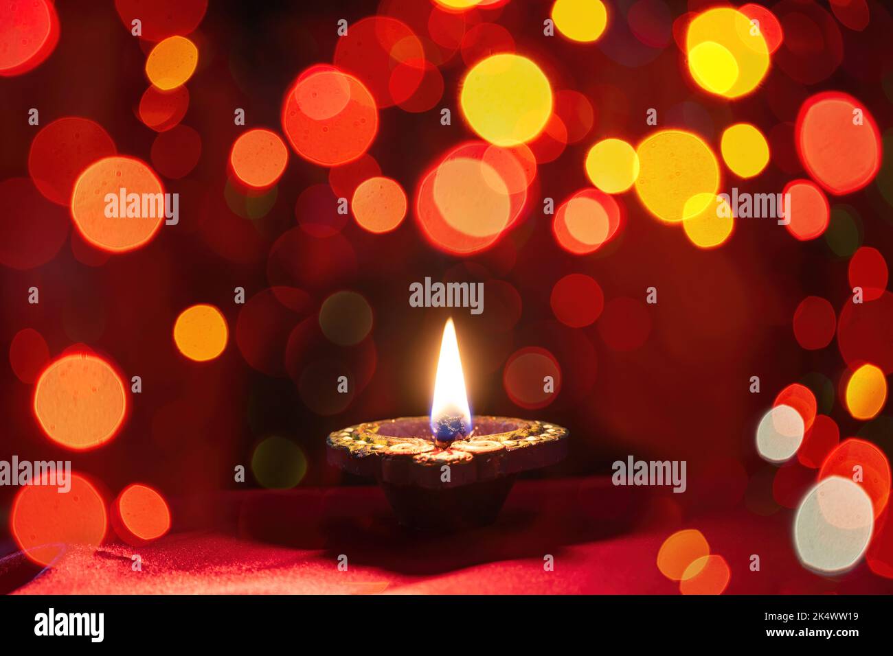 Happy Diwali. Diya lamp lit, colorful rangoli, dark bokeh light ...