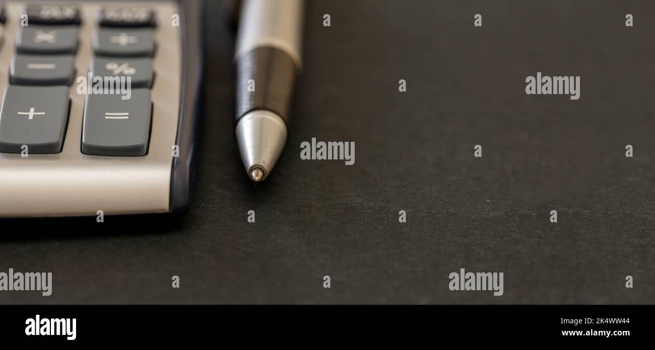 Financial accounting. Pen and calculator on black color background ...