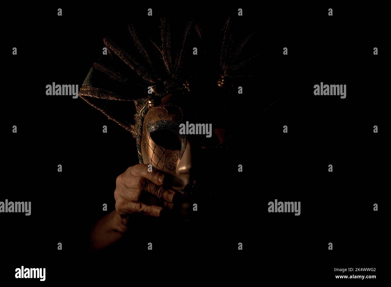 Venetian carnival mask in the dark in the hands of an old woman ...
