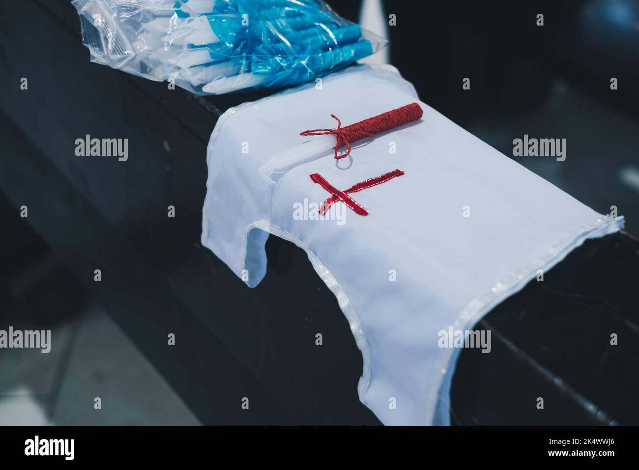 White sleeveless satin dress gown for child and candle with red string ...