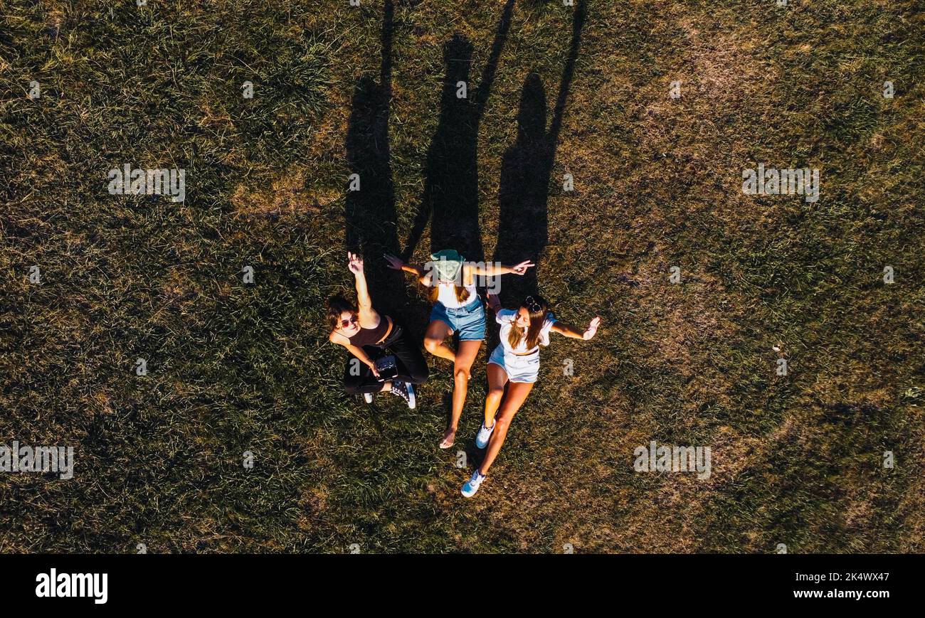 bird's eye view of three women lying on the grass Stock Photo - Alamy