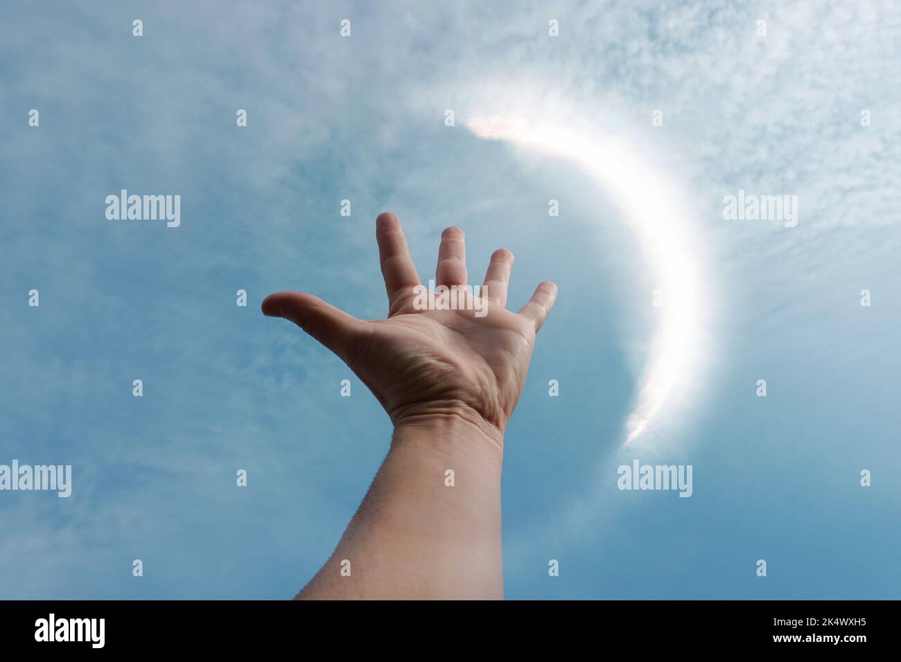 hand up in the air playing with the sunlight, blue background Stock ...