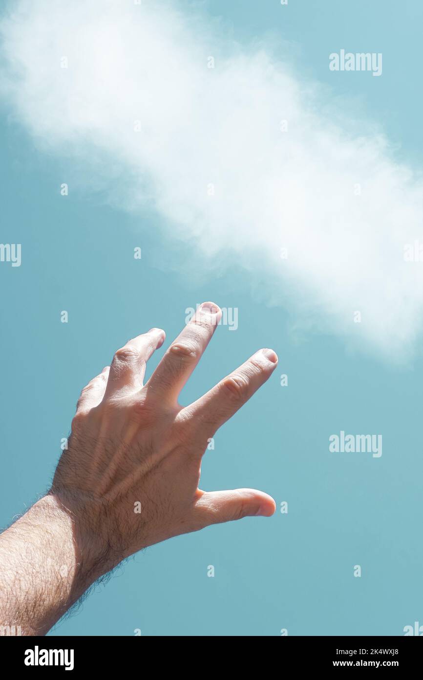 hand up in the air playing with the sunlight, blue background Stock ...