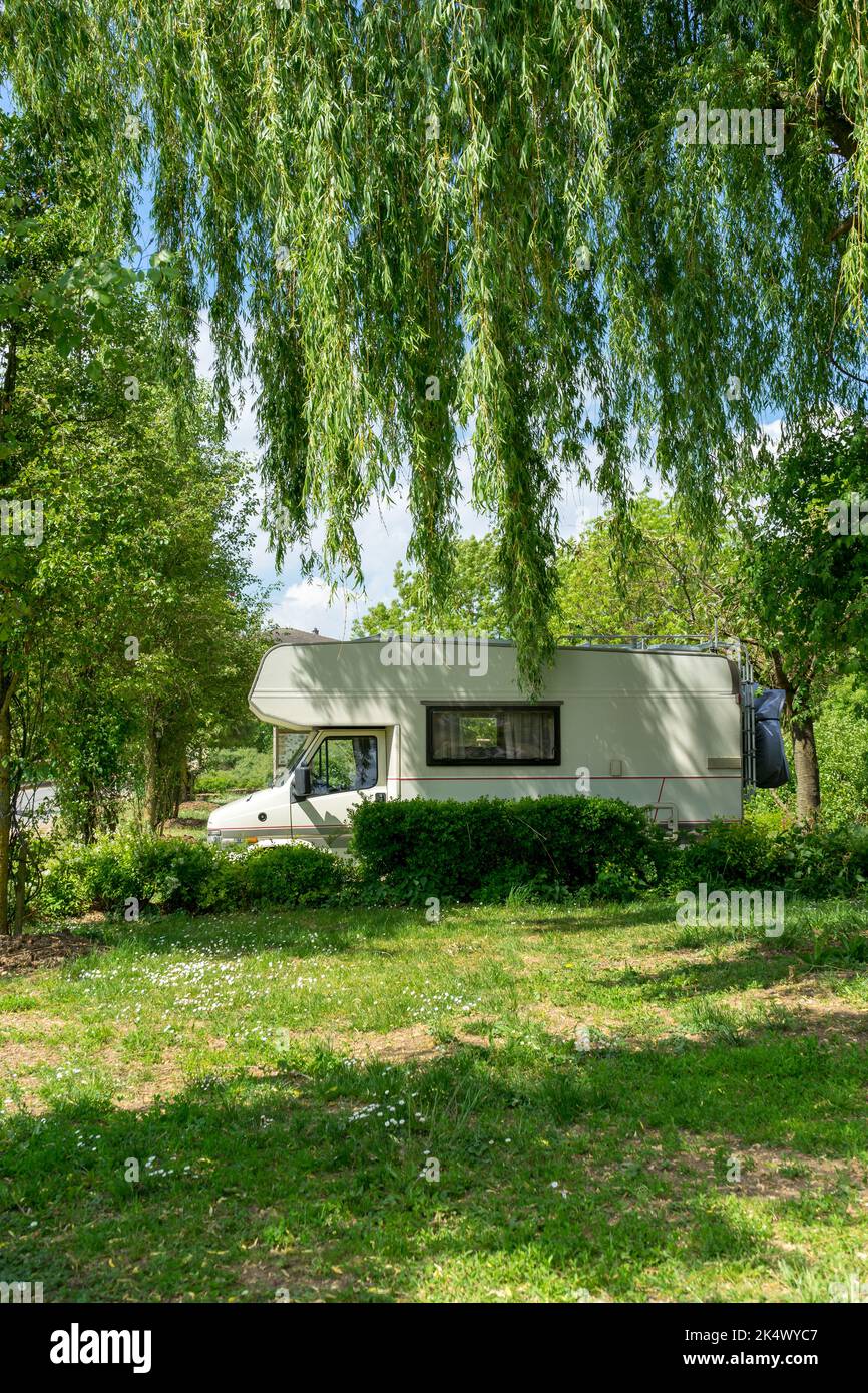 Motorhome parked between trees in the middle of nature Stock Photo - Alamy