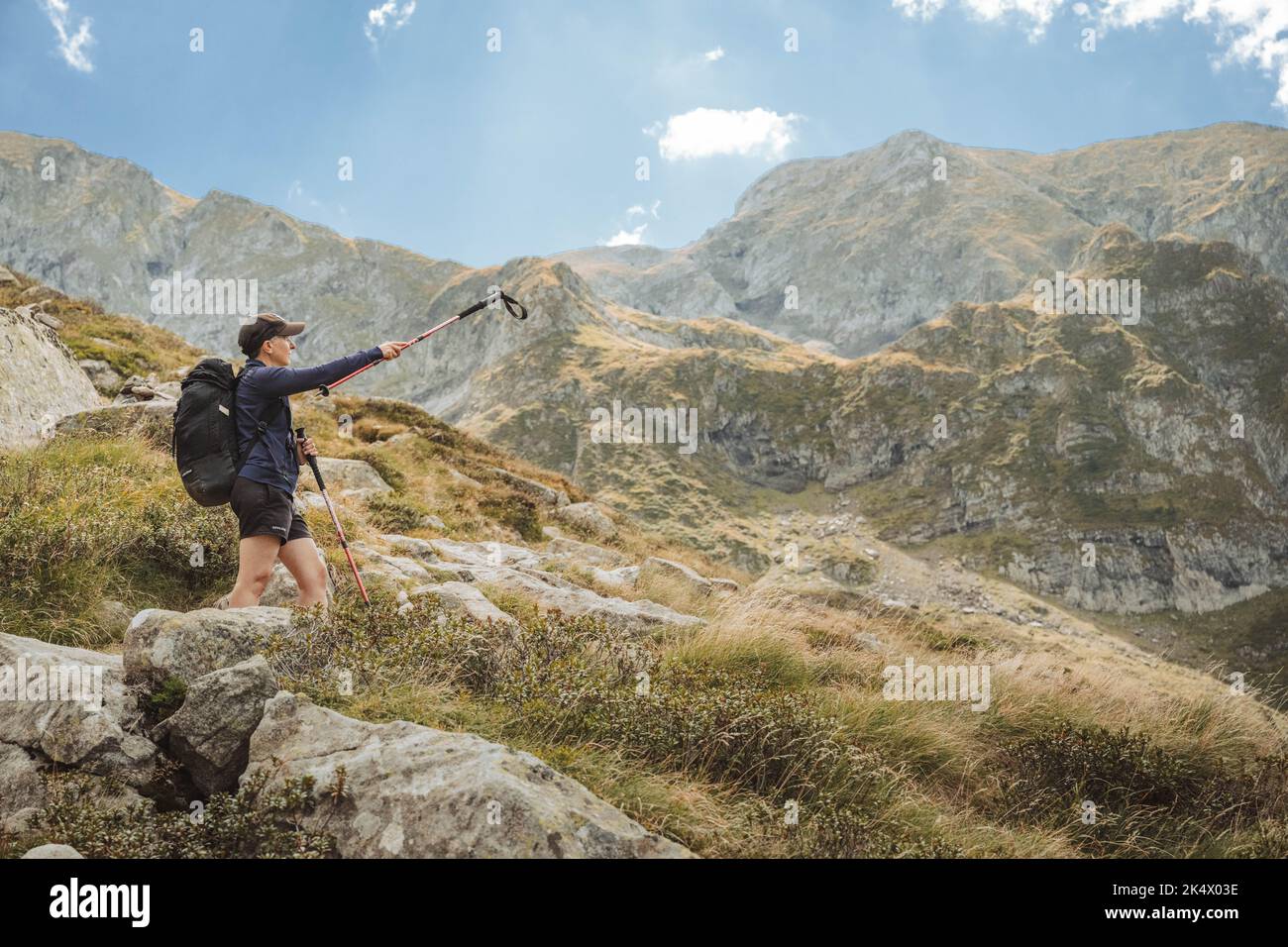 A hiker pointing towards a mountain range in the Pyrenees Stock Photo ...