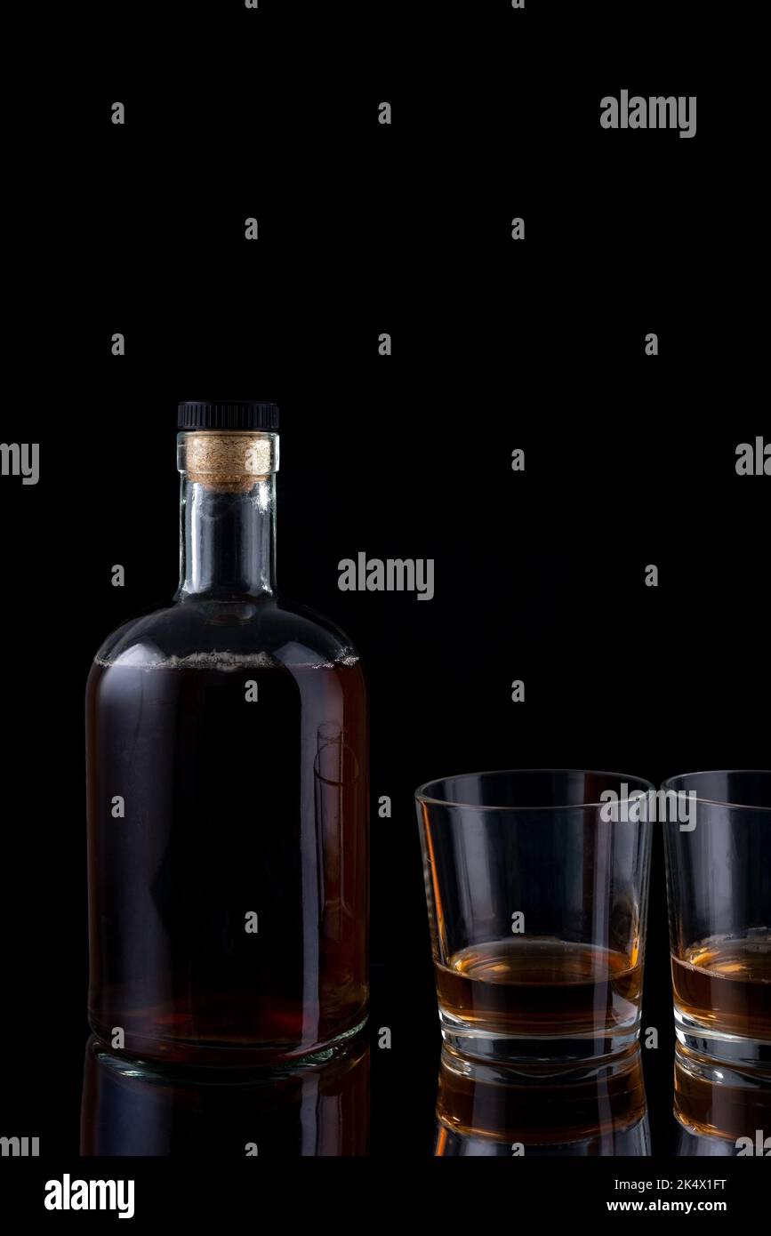 bottle of strong alcohol brandy with glasses on black background Stock ...