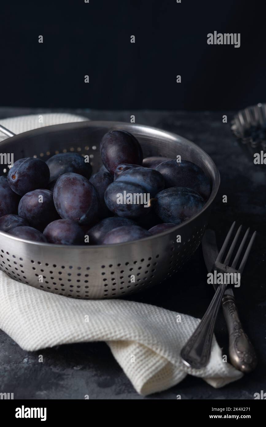 dramatic autumn still life with plums on a dark background. Rustic ...