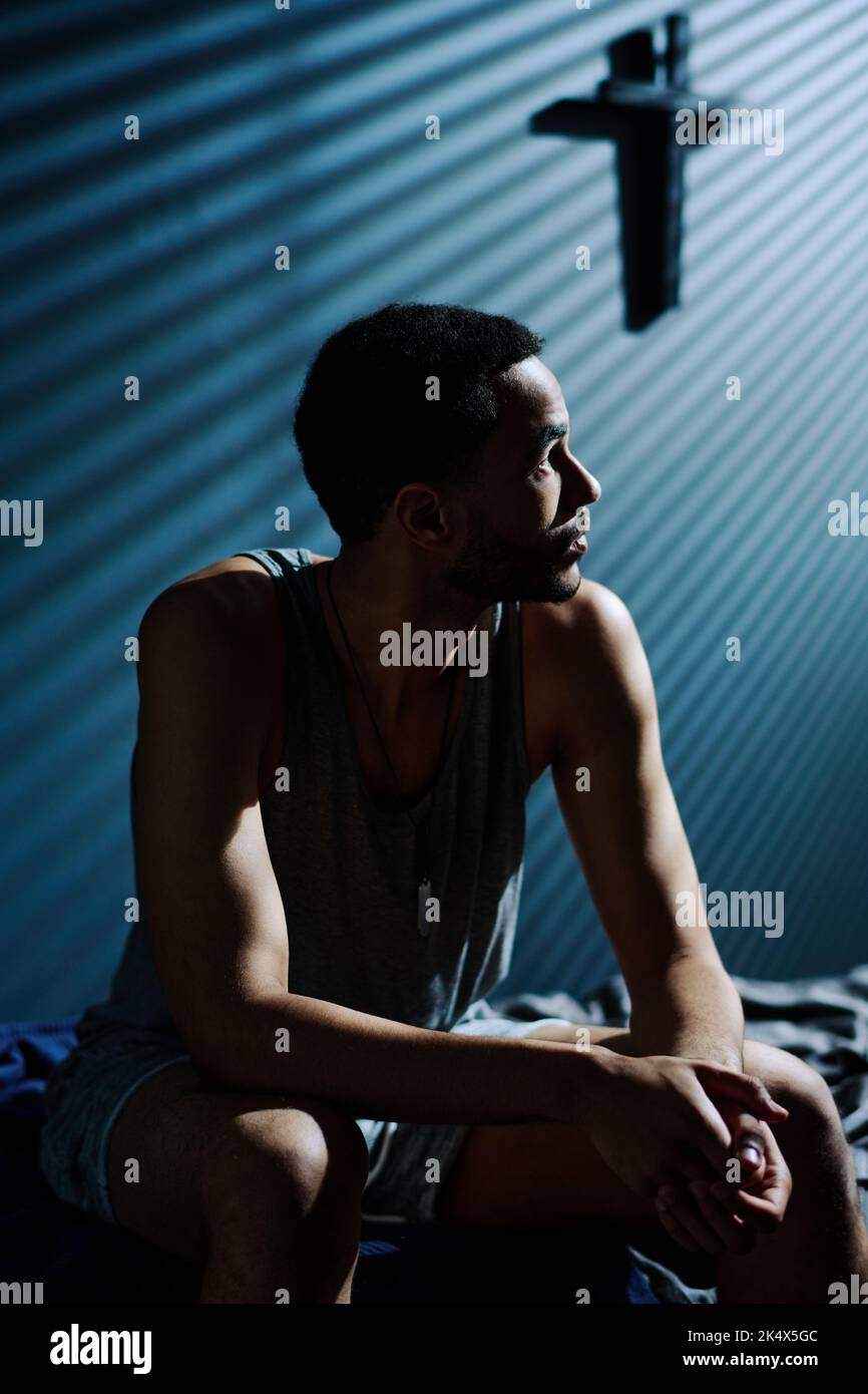 Young tired and unhappy man looking at moonlight coming through window ...