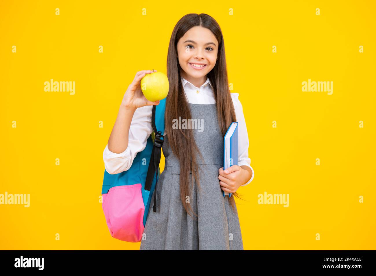 Schoolchild, teenage student girl hold book on yellow isolated studio ...