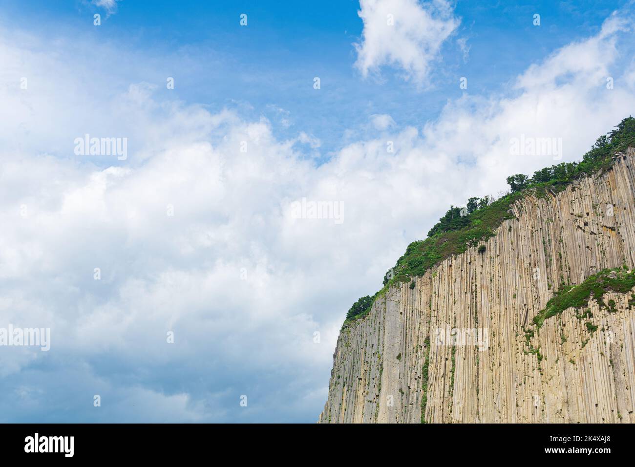 top of columnar volcanic basalt cliff against the background of the sky ...