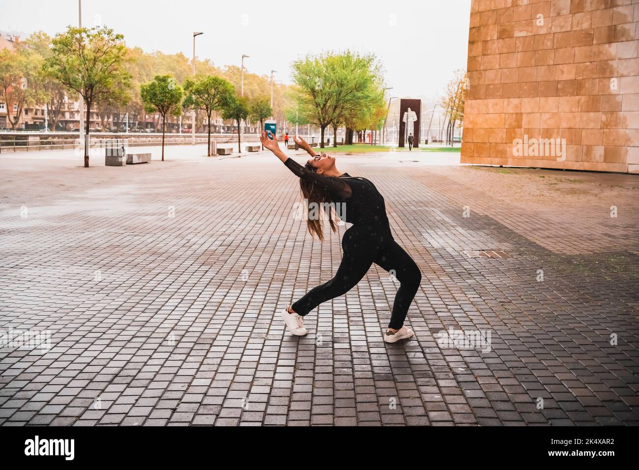 Attractive caucasian woman dancing in the rain and enjoying with drops ...