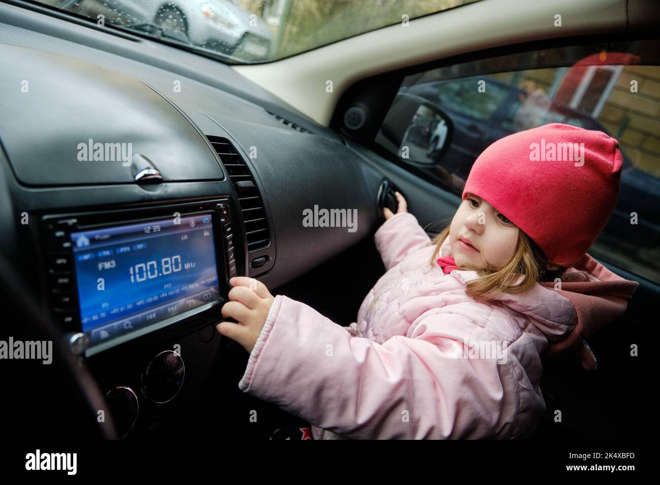 A little girl Changing Radio Station While Listening Music In Car ...