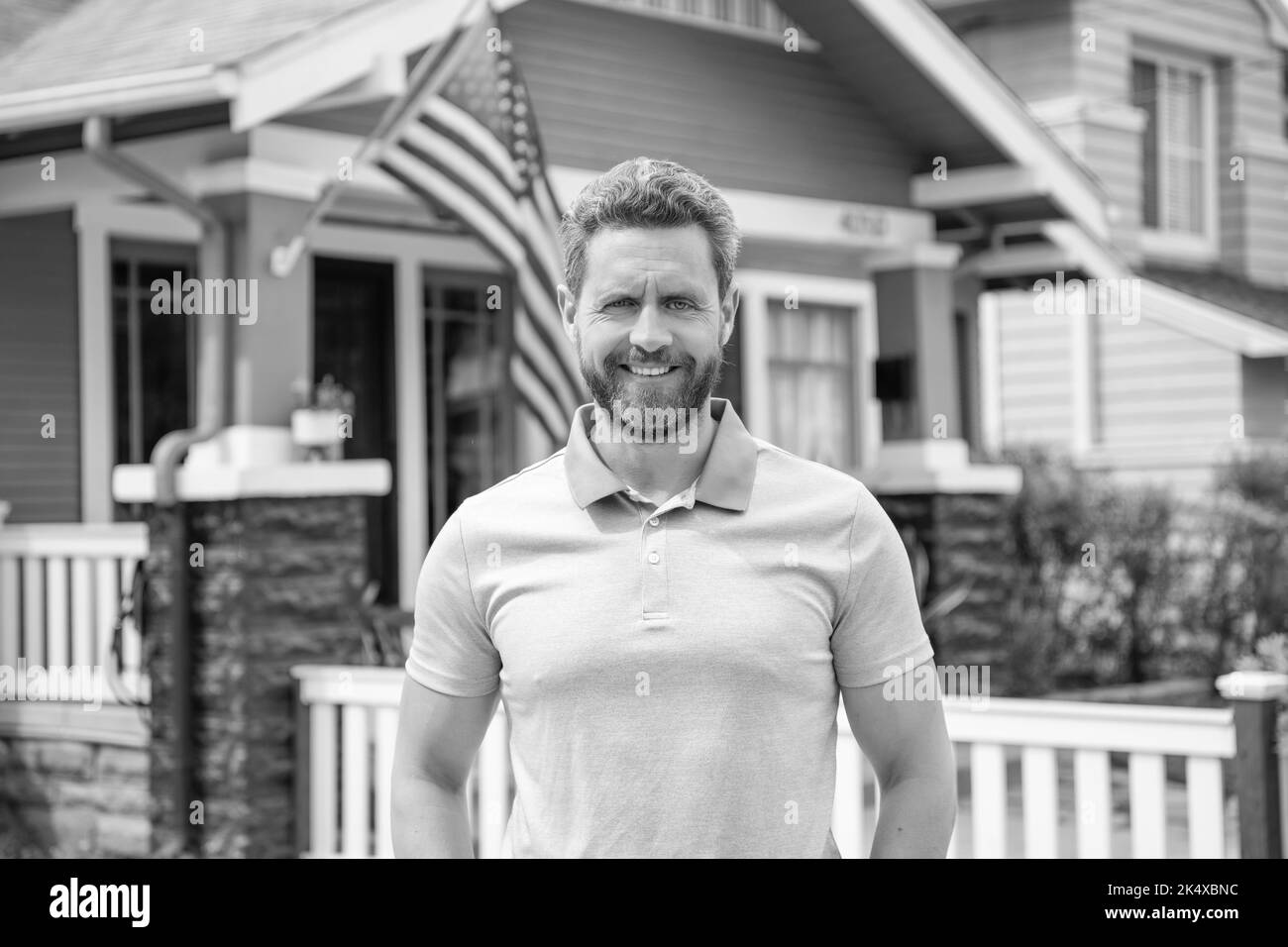happy bearded man realtor selling or renting house with american flag ...