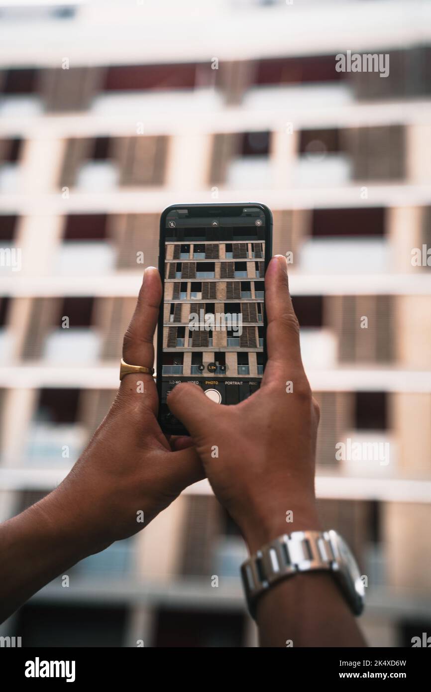 A man using a Phone shooting a modern exterior building Stock Photo - Alamy