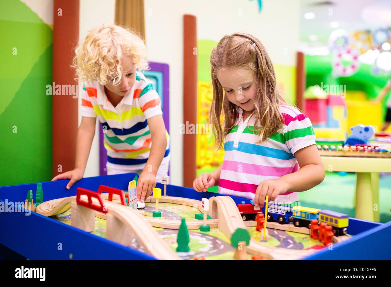 Kids play toy railroad. Little blond curly boy with wooden trains in ...
