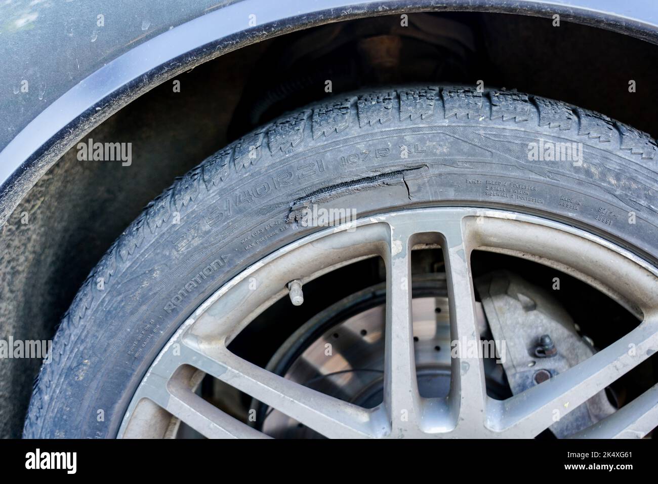 A large long mechanical cut on the sidewall of a passenger car tire ...