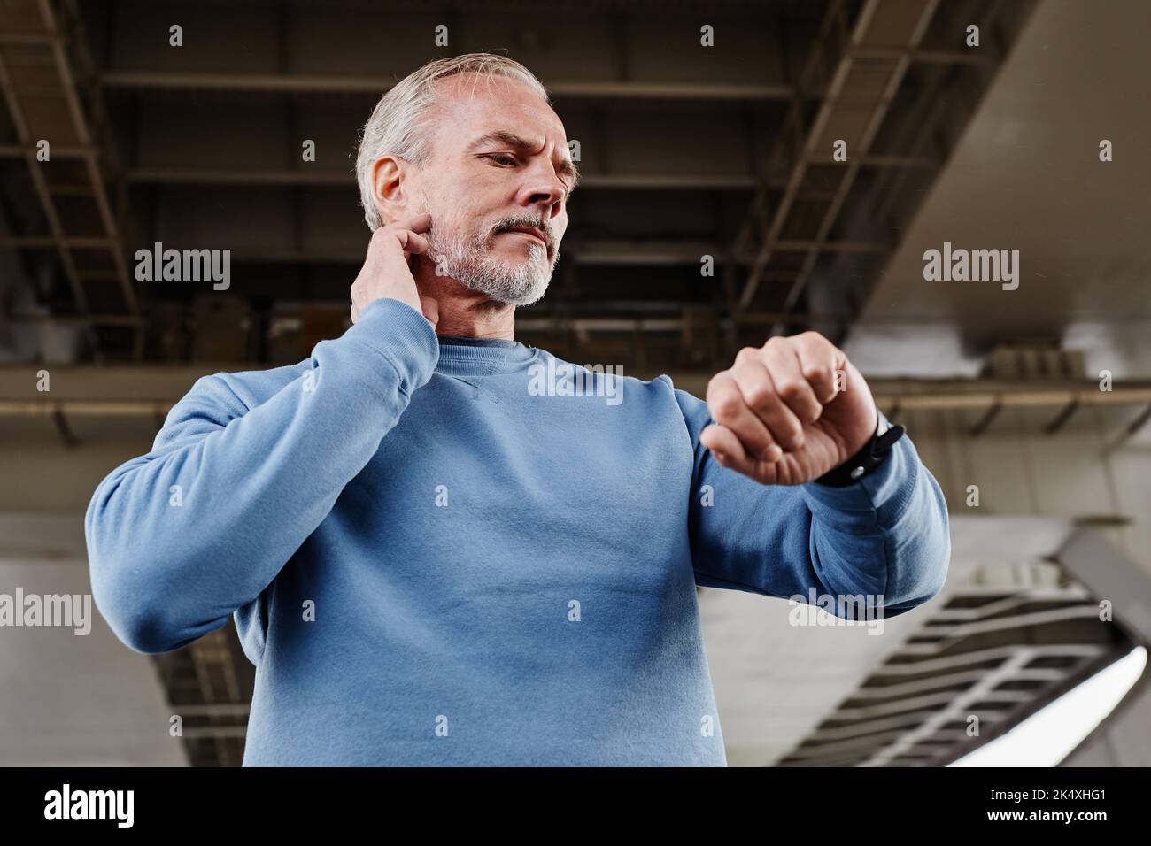 Low angle portrait of handsome mature man tracing pulse rate with ...