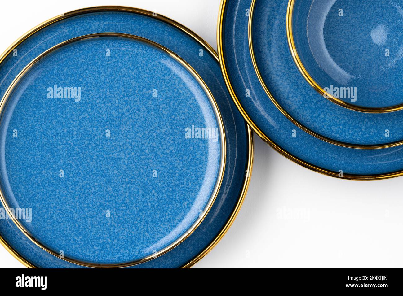 A Set of blue ceramic plates on a white background Stock Photo - Alamy
