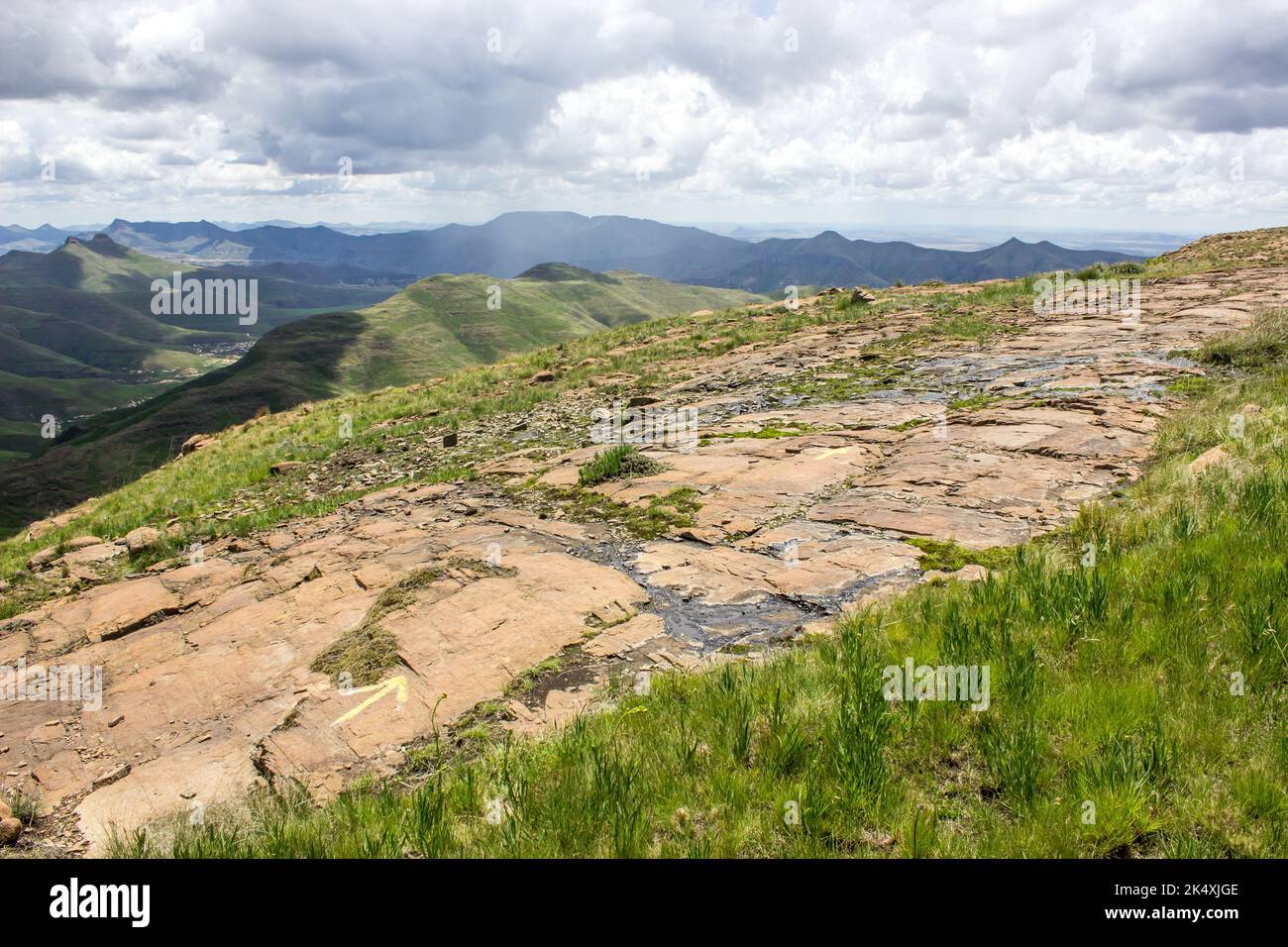 At the cliffs edge, with the distant blue and green mountains of the ...