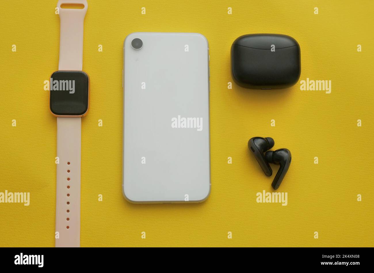 Mockup of a smartphone on a yellow background. Headphones, smart watch ...