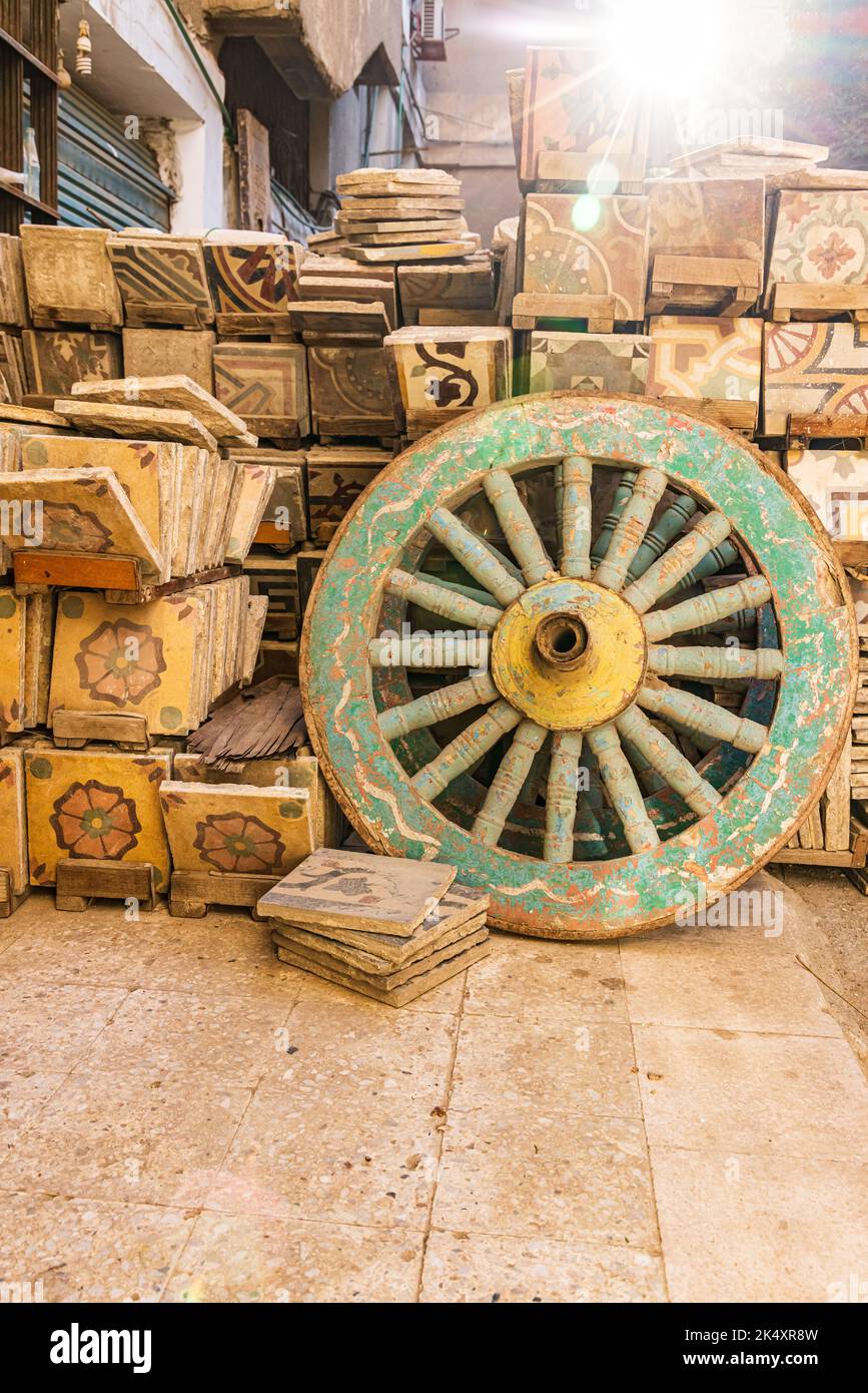 Old Cairo, Cairo, Egypt. Wooden cart wheel and floor tiles in an alley ...
