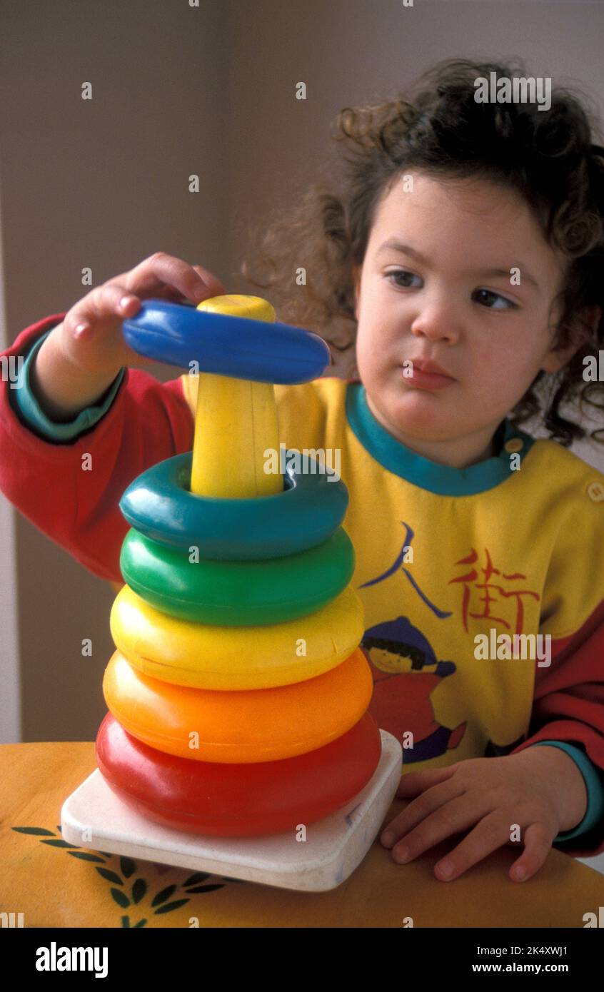 Little girl playing with coloured stacking rings Stock Photo - Alamy