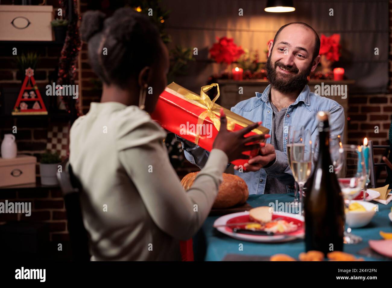Couple celebrating christmas together, exchanging presents at festive ...