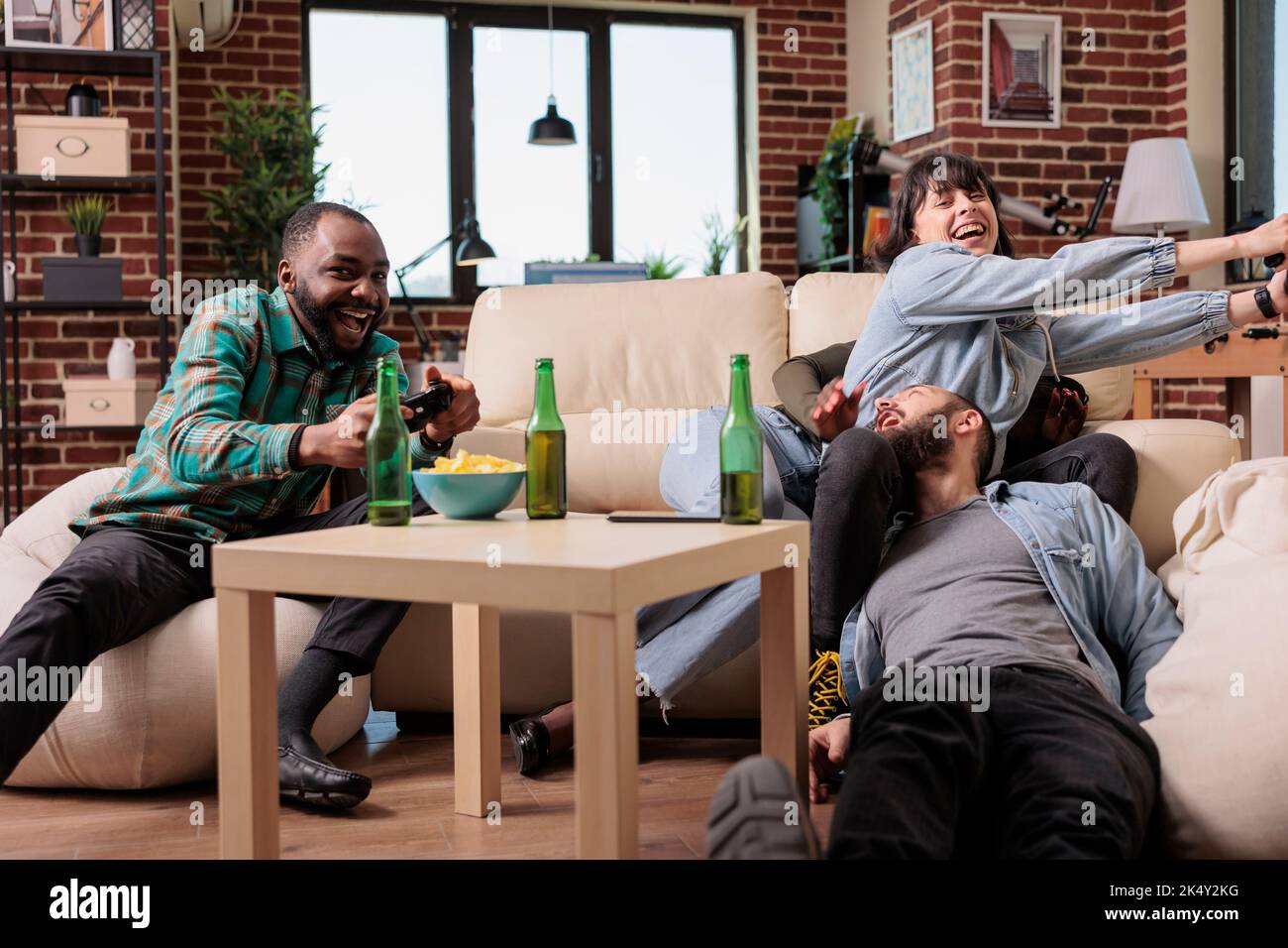 Diverse group of friends feeling happy and playing video games on ...