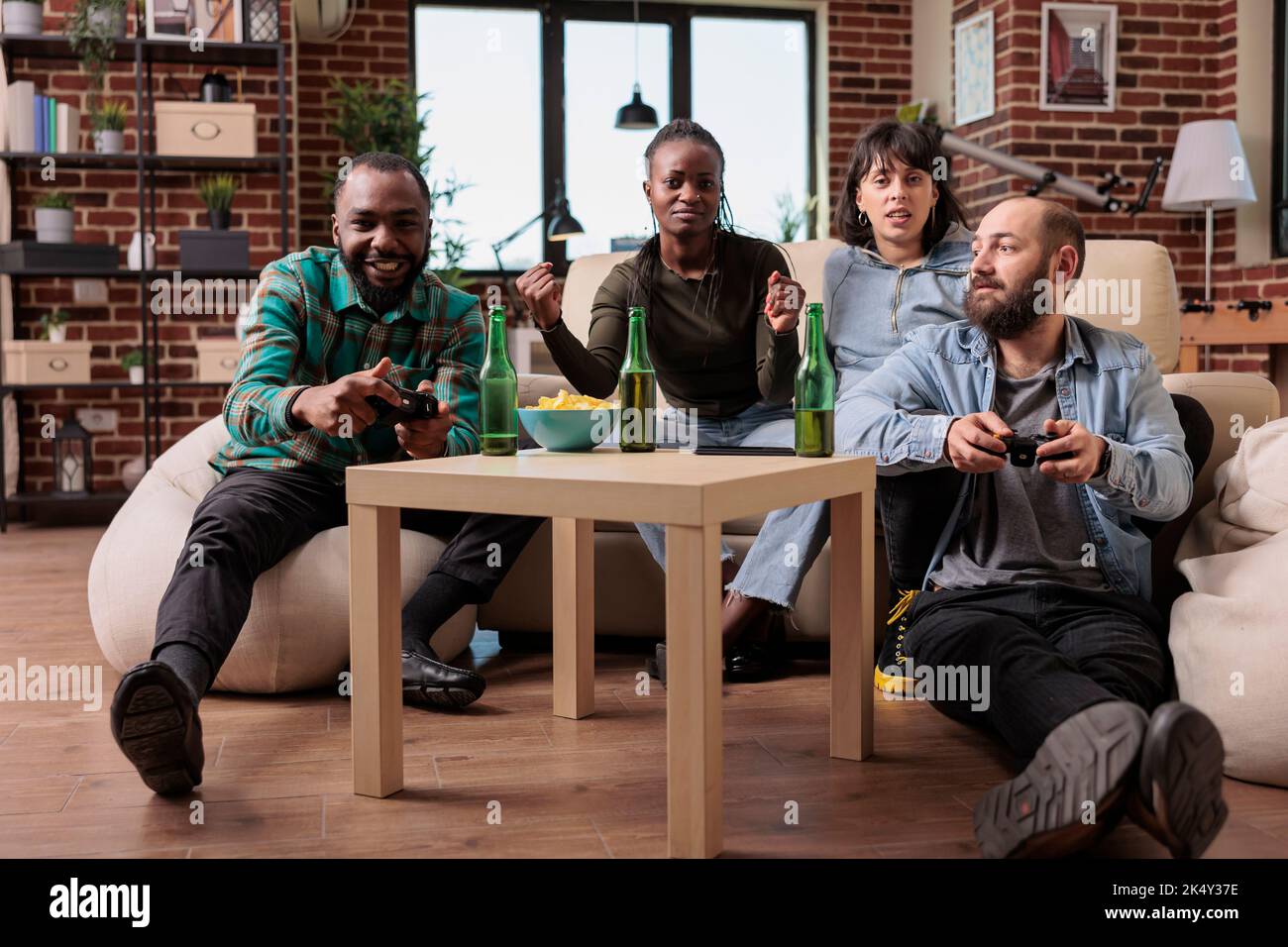 Group of friends having fun with video games competition and drinking ...