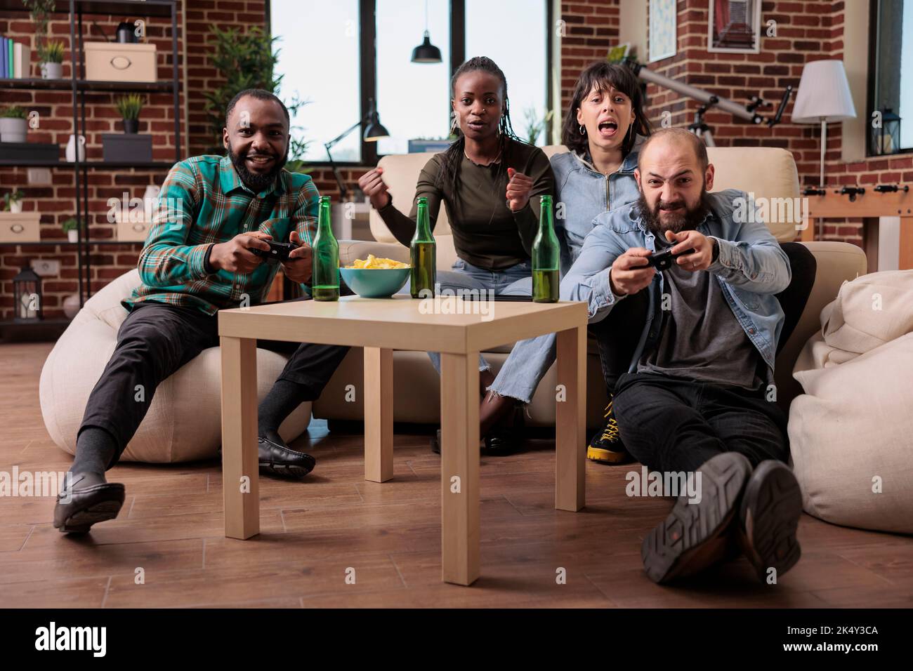 Happy friends laughing while they play strategy video games, using ...