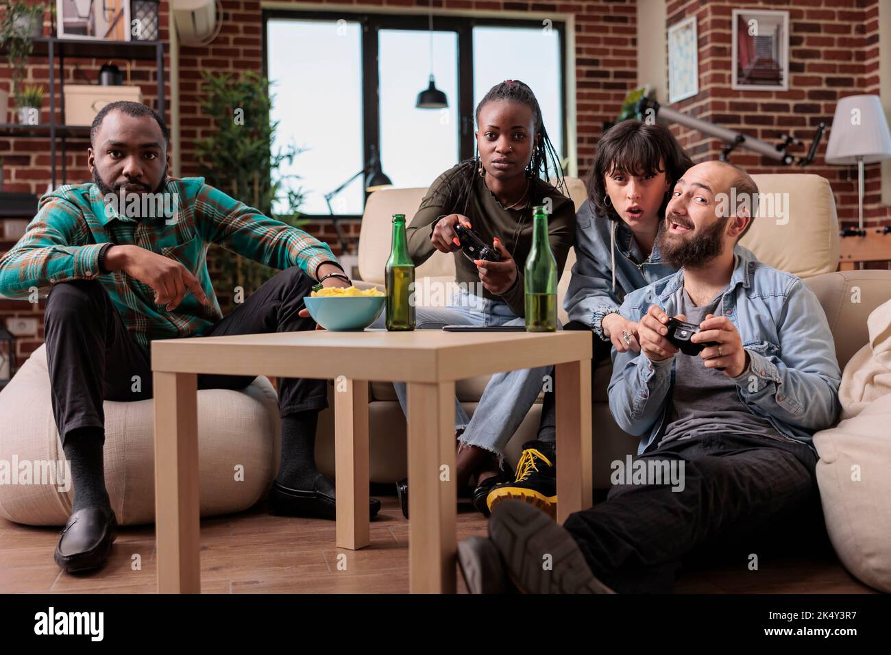 Multiethnic group of friends using joysticks to play video games on ...