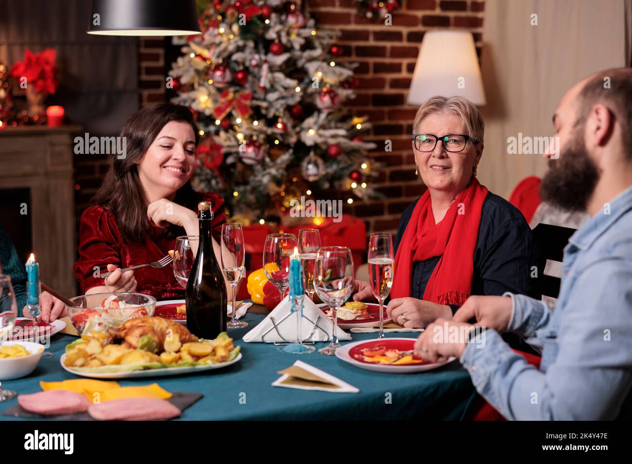 Woman and man celebrating christmas with parents, family sitting at ...
