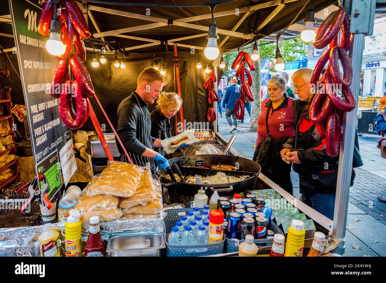 Open air food stall selling gourmet sausages to customers along the ...