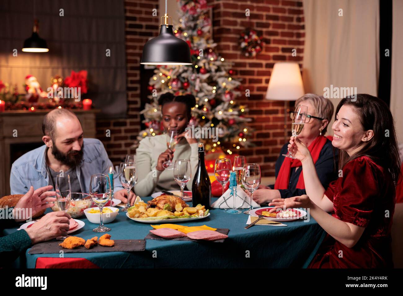 Family drinking sparkling wine at christmas festive dinner, celebrating ...