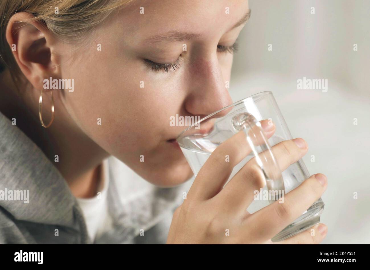 The girl drinks water from a transparent glass cup Stock Photo - Alamy