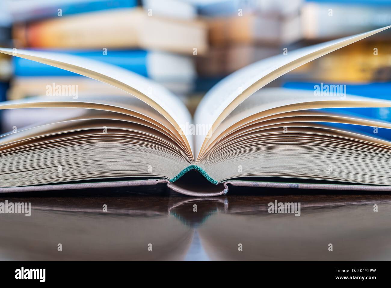Closeup opened book on library desk Stock Photo - Alamy