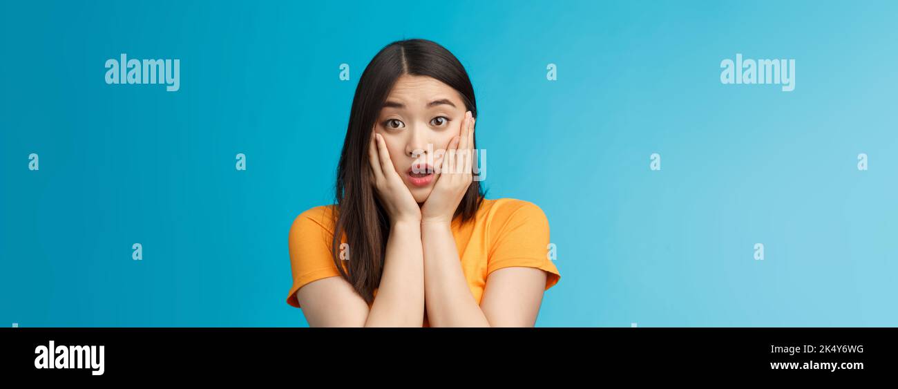 Close-up concerned shocked young timid asian girl gasping, dropping jaw ...