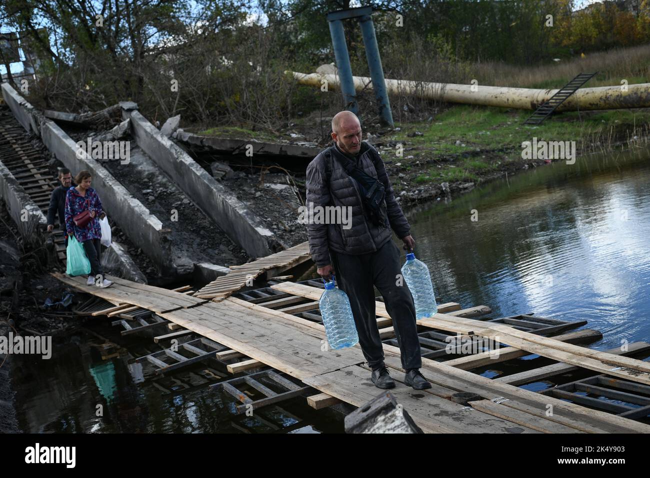 Residents of Bakhmut city cross Bakmutovka River via an improvised ...